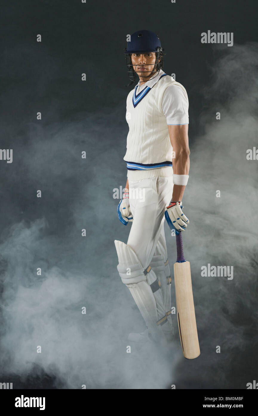 Portrait of a cricket batsman standing with a bat Stock Photo - Alamy