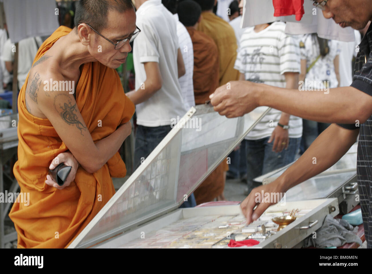 A monk peruses merchandise during Wai Kru Day at Wat Bang Phra, a ...