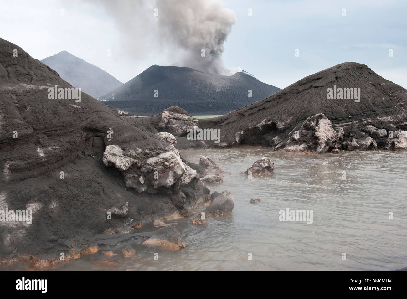 A Hot Volcanic Spring and Volcano Tavurvur Erupting a Plume of Ash in ...
