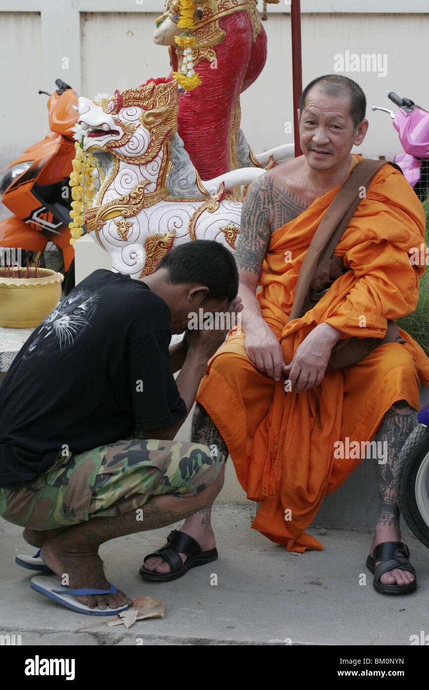 A devotee pays his respects to a monk at Wat Bang Phra, a Buddhist ...