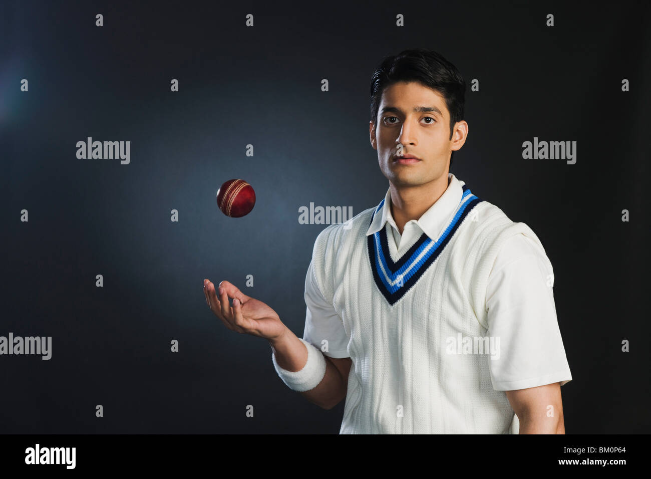Portrait of a cricket player tossing a cricket ball Stock Photo - Alamy