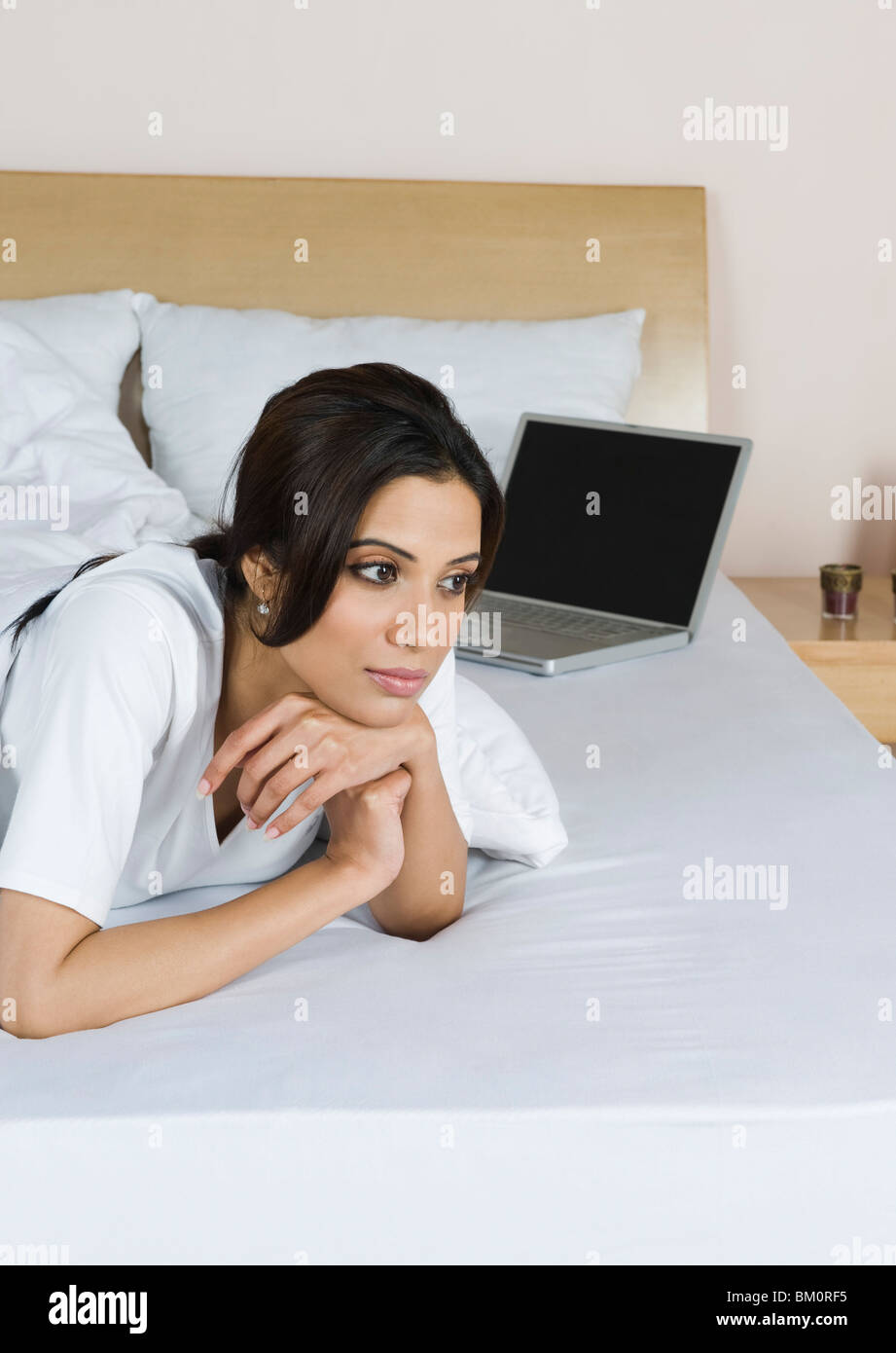 Woman lying on the bed and thinking Stock Photo - Alamy