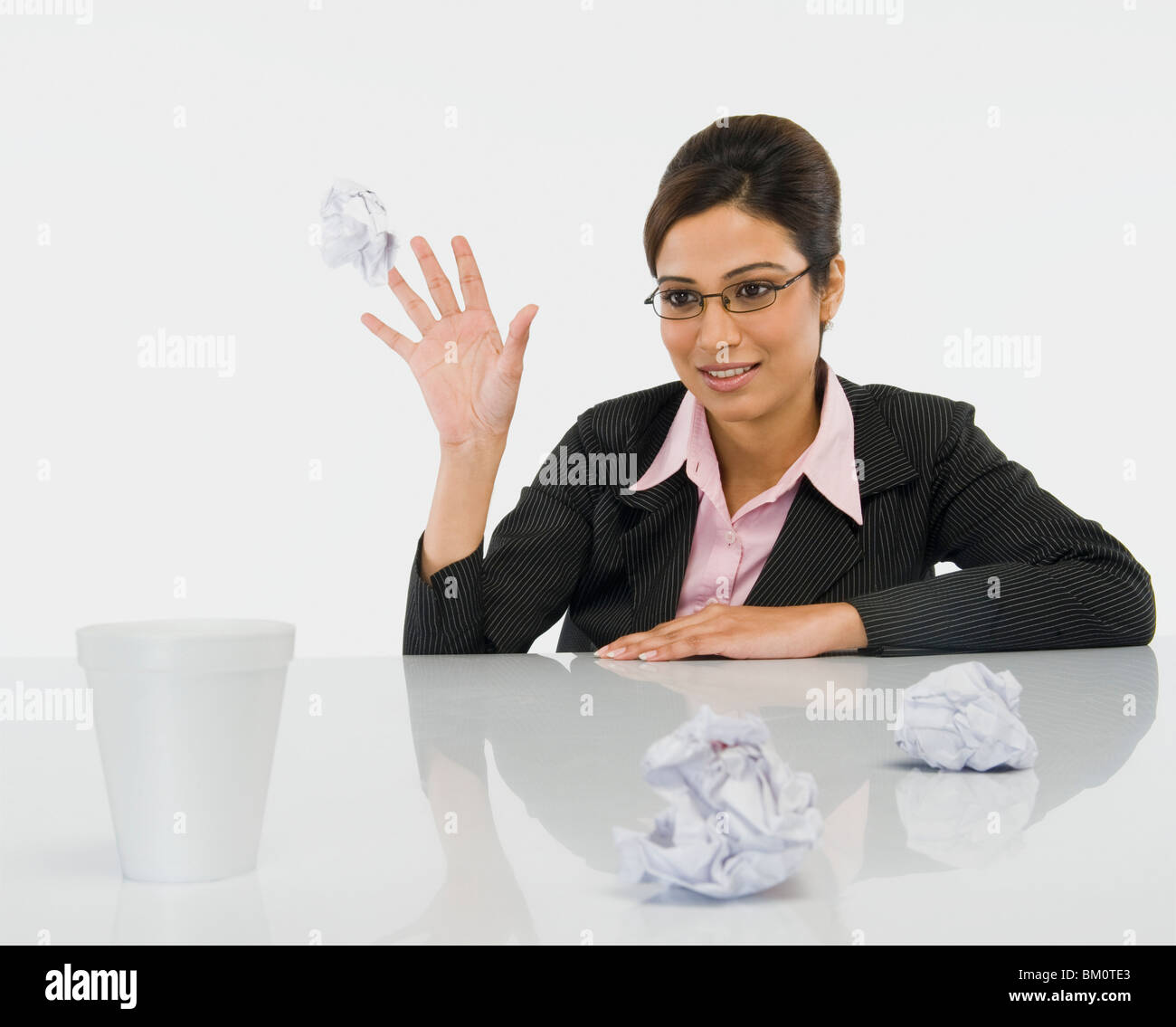 Businesswoman throwing crumpled paper into waste basket Stock Photo - Alamy
