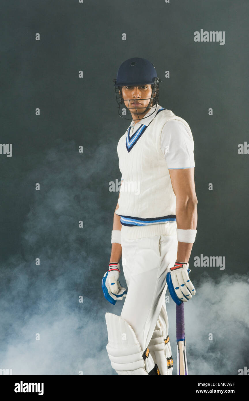 Portrait of a cricket batsman standing with a bat Stock Photo - Alamy