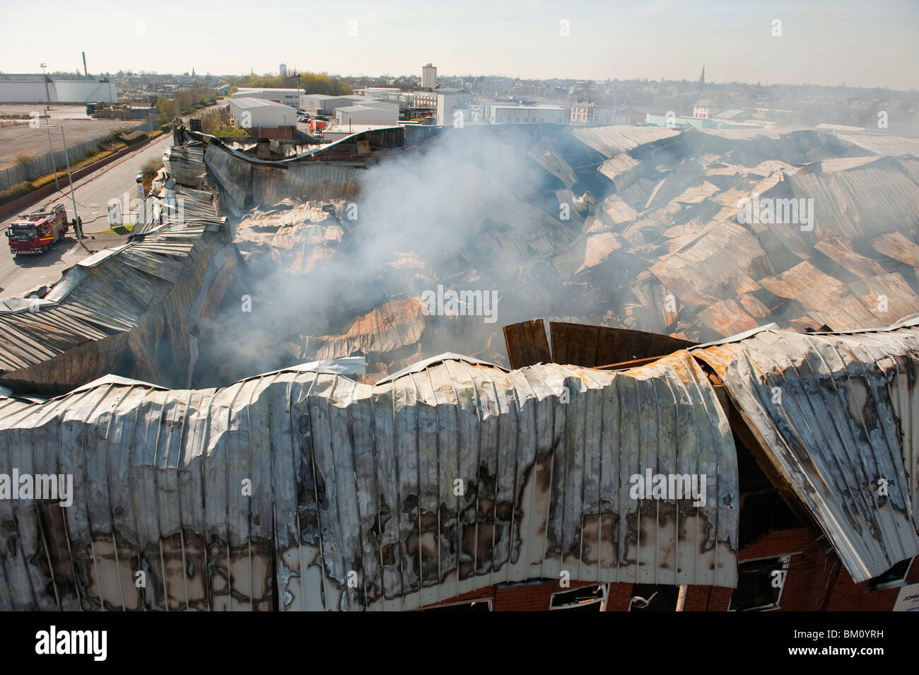 Large factory and warehouse collapsed and smoldering following major ...