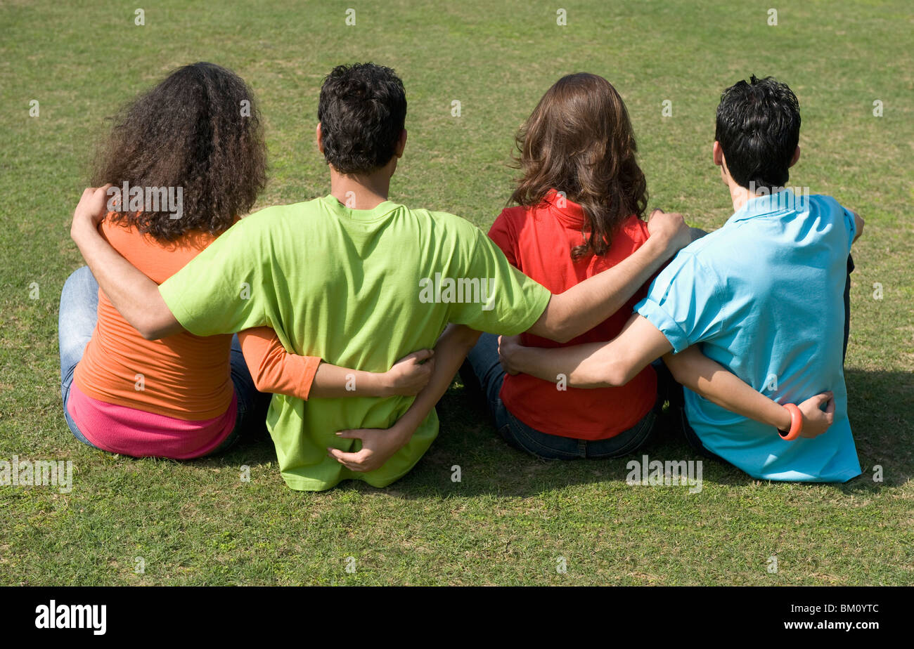 Rear view of friends sitting in a park Stock Photo - Alamy
