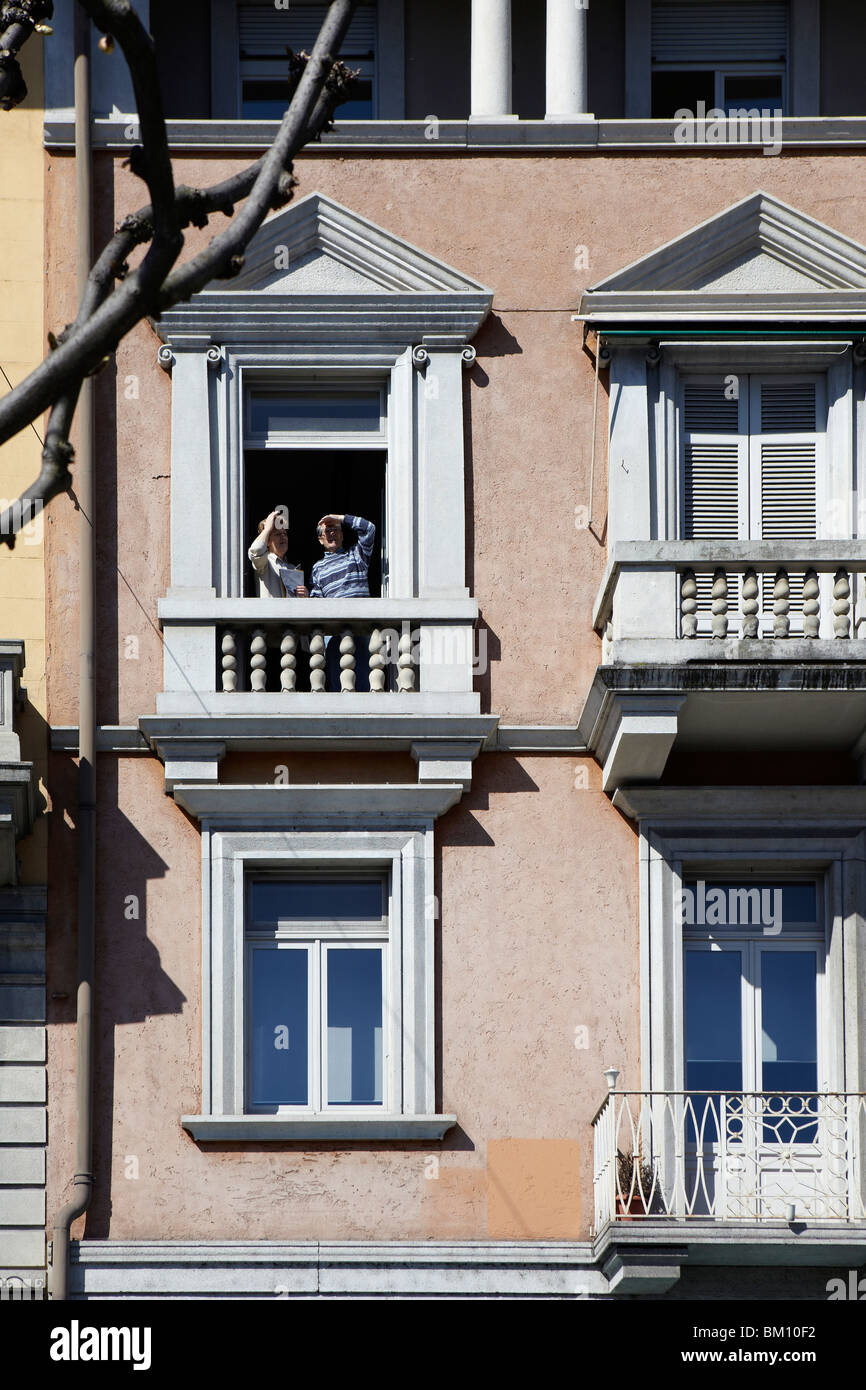 Two people looking out a window in Lugano, Switzerland Stock Photo - Alamy