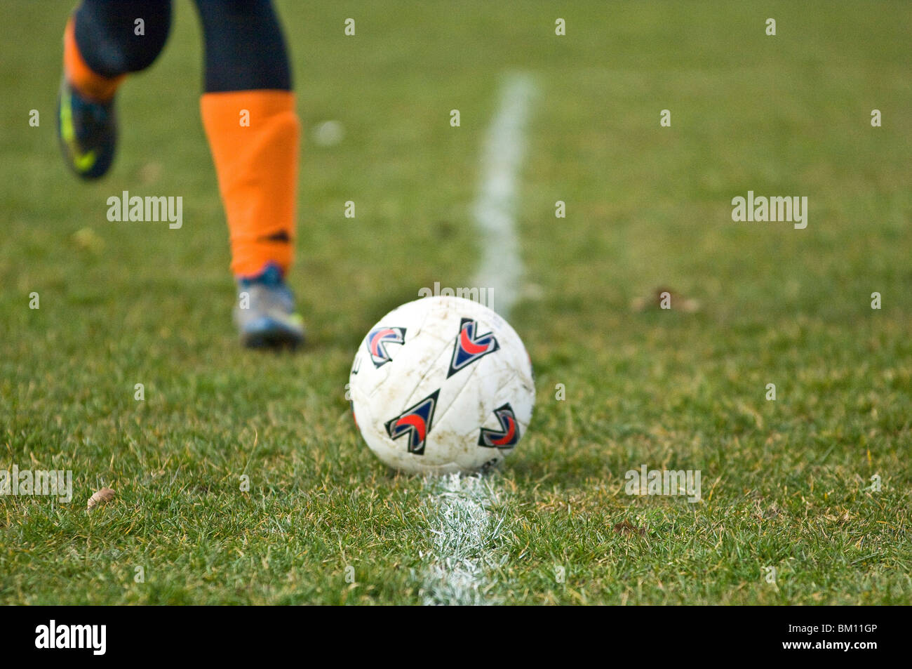 A close up of a female football players legs running towards a football ...