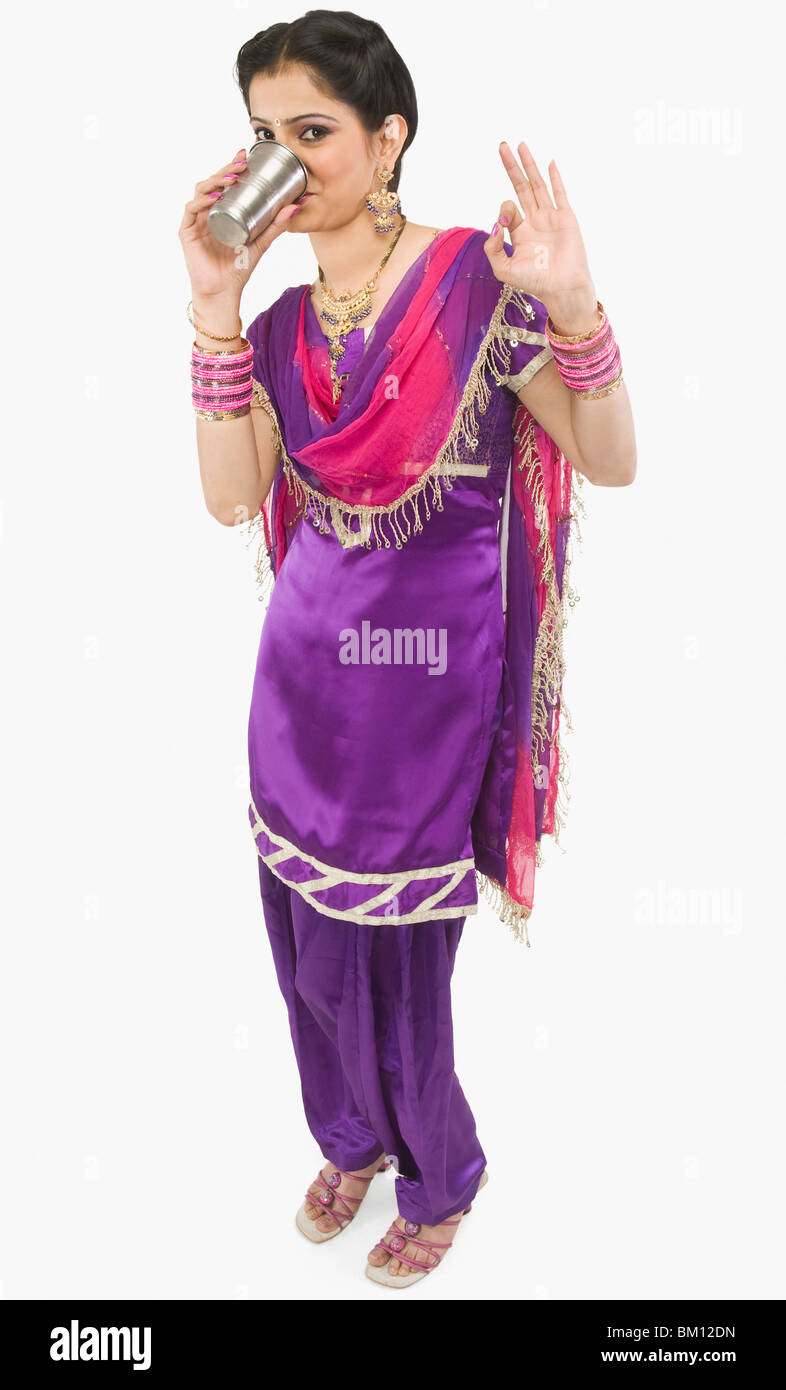 Woman drinking lassi and gesturing Stock Photo - Alamy