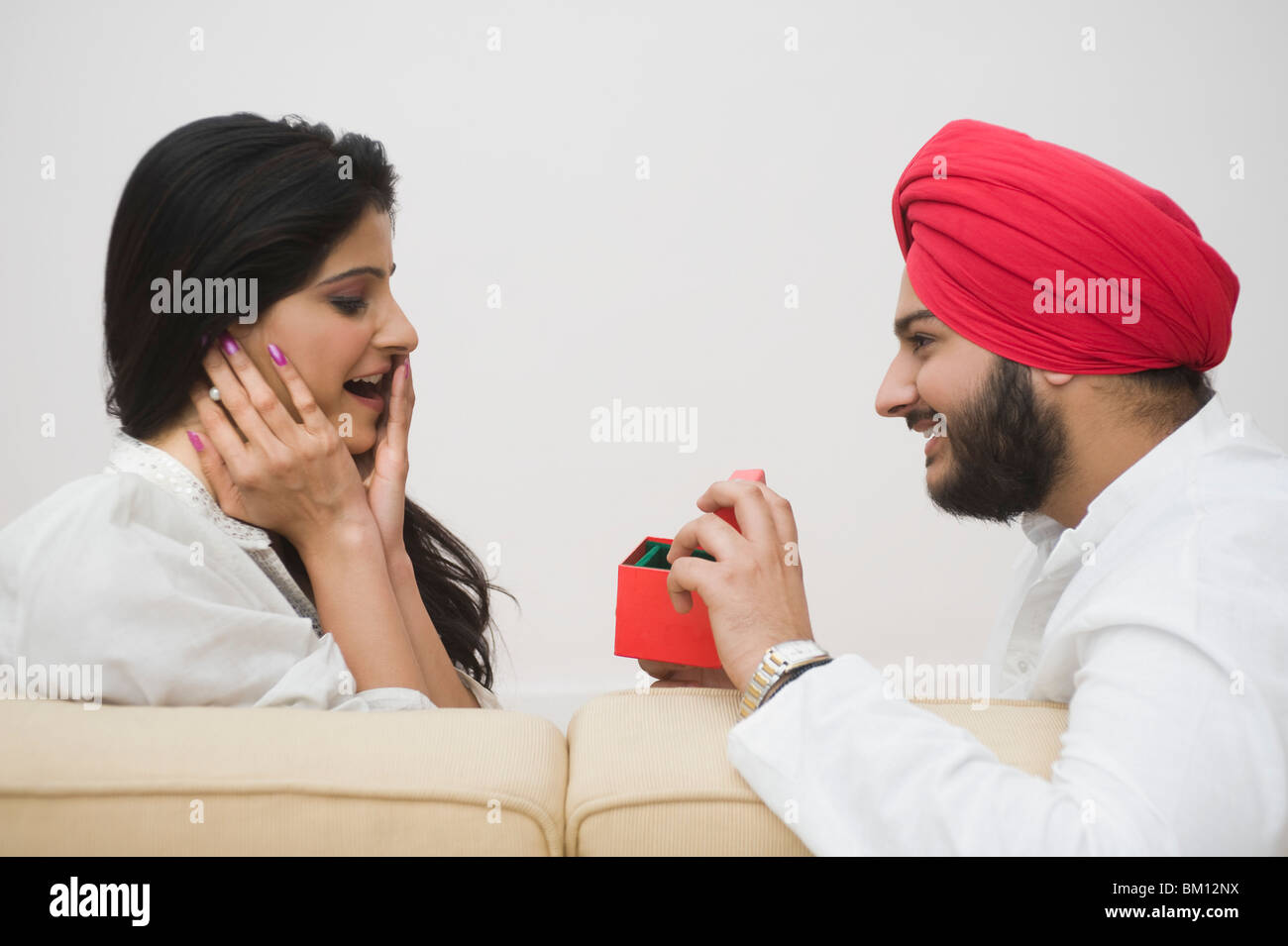 Man presenting a gift to his wife Stock Photo - Alamy