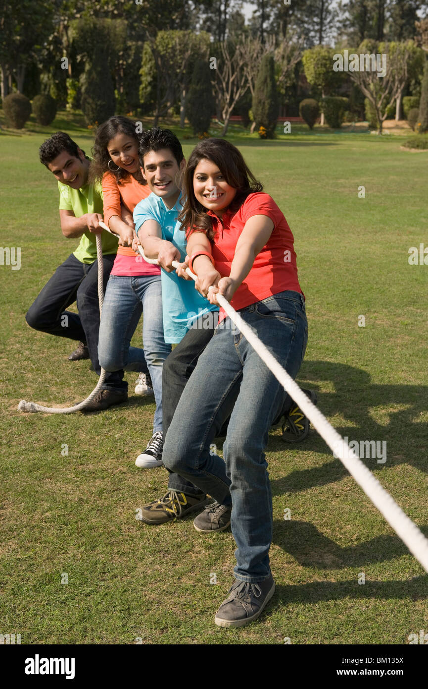 Friends pulling rope in a park Stock Photo - Alamy