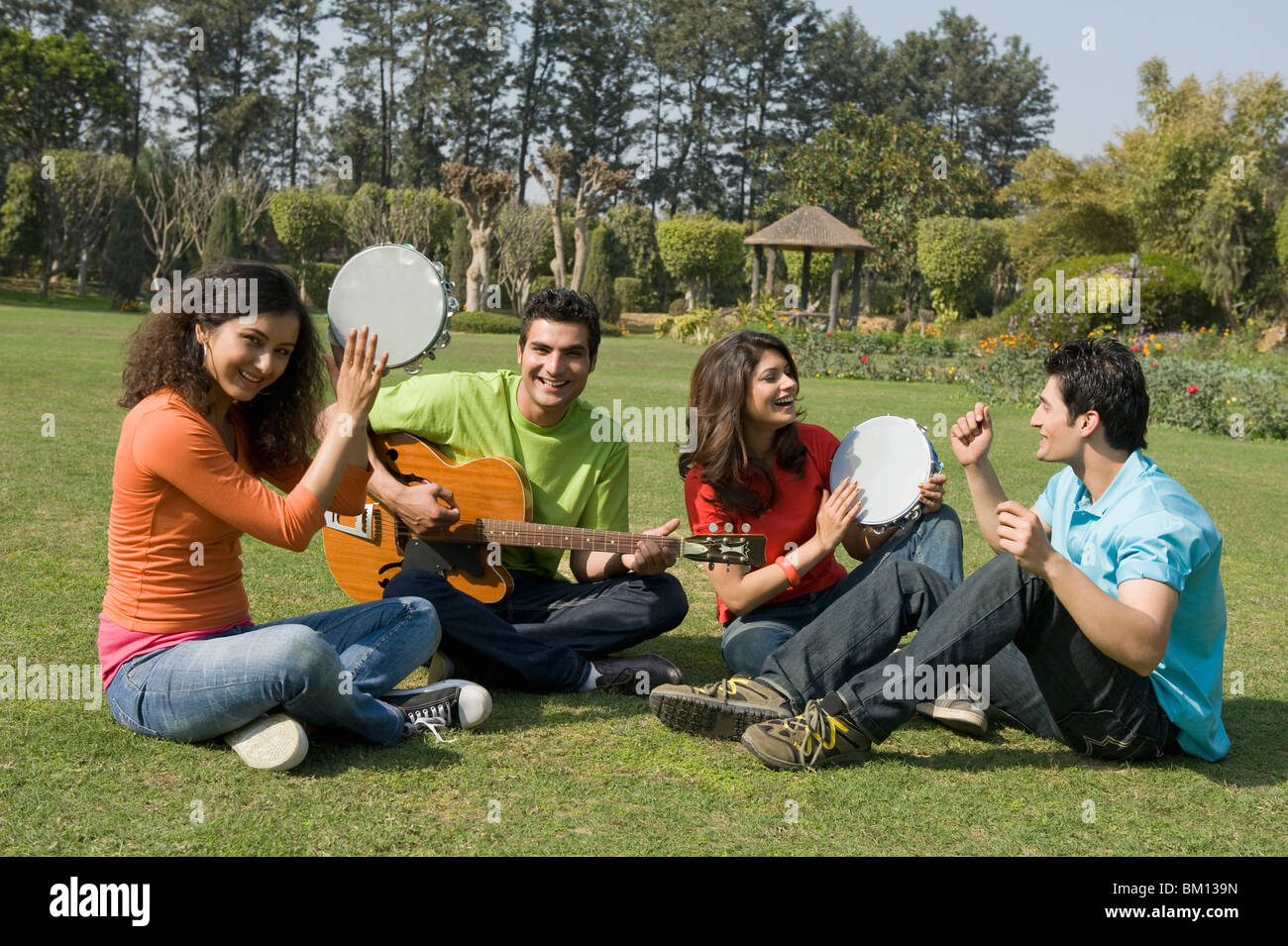 Friends enjoying music in a park Stock Photo - Alamy