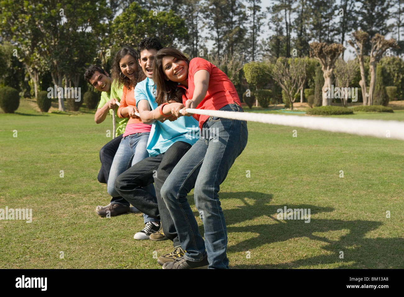 Friends pulling rope in a park Stock Photo - Alamy