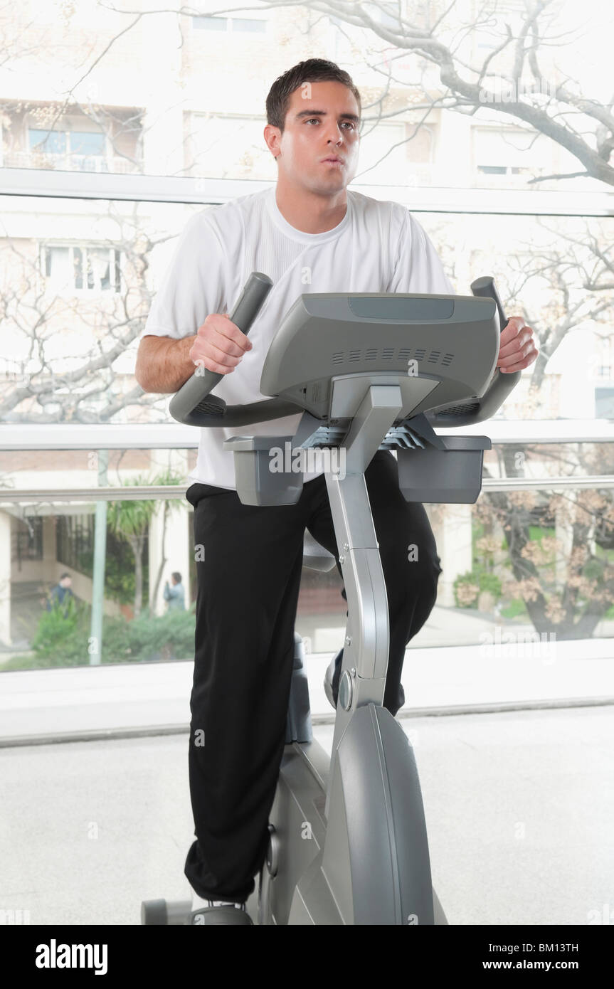 Man working out on an exercise bike in a gym Stock Photo - Alamy