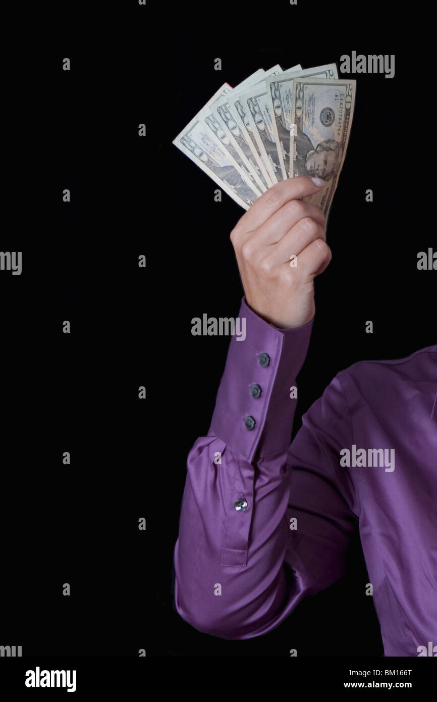 Person's hand holding fanned out currency notes Stock Photo - Alamy