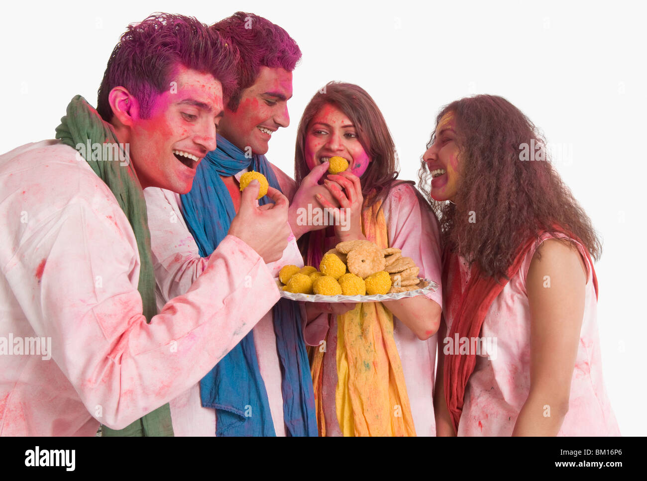 Friends eating laddu on Holi Stock Photo - Alamy