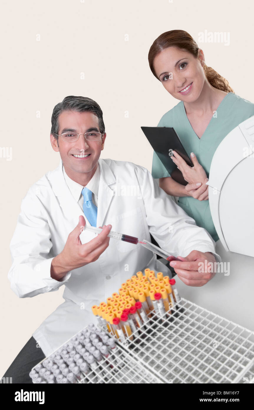 Lab technician filling blood in a test tube from a syringe Stock Photo ...