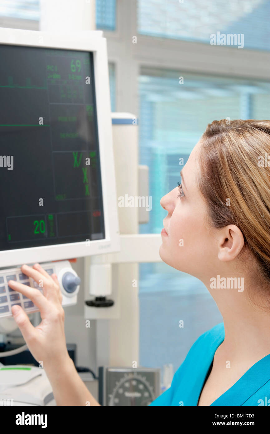 Female doctor working on a cardiac monitor Stock Photo - Alamy