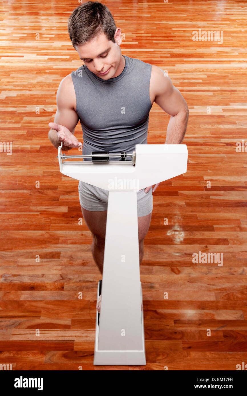 Man measuring his weight on a weighing scale Stock Photo - Alamy