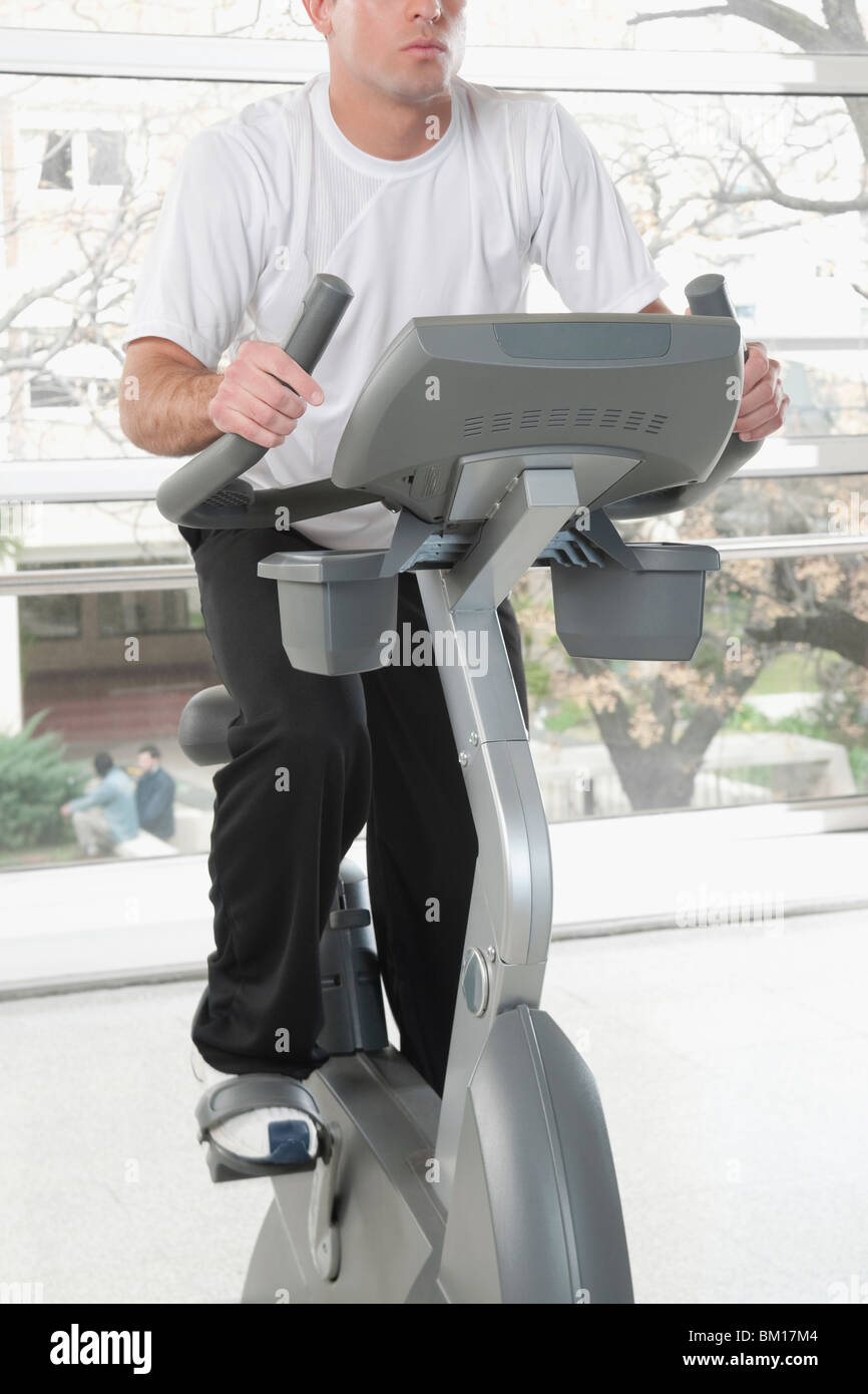 Man working out on an exercise bike in a gym Stock Photo - Alamy