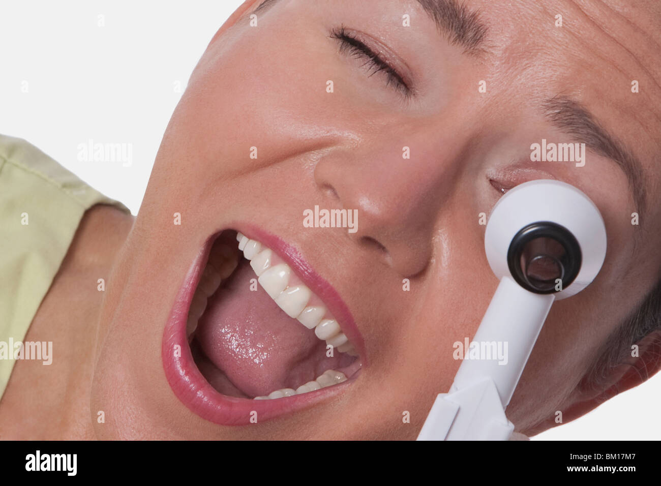 Female doctor looking through an otoscope Stock Photo - Alamy