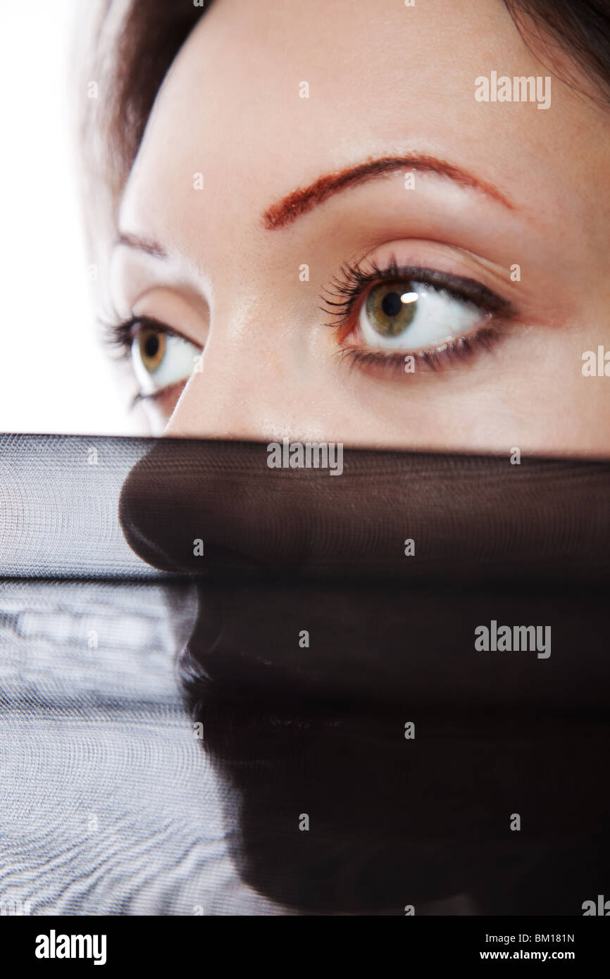 Model half of the face covered with a black transparent fabric, a ...