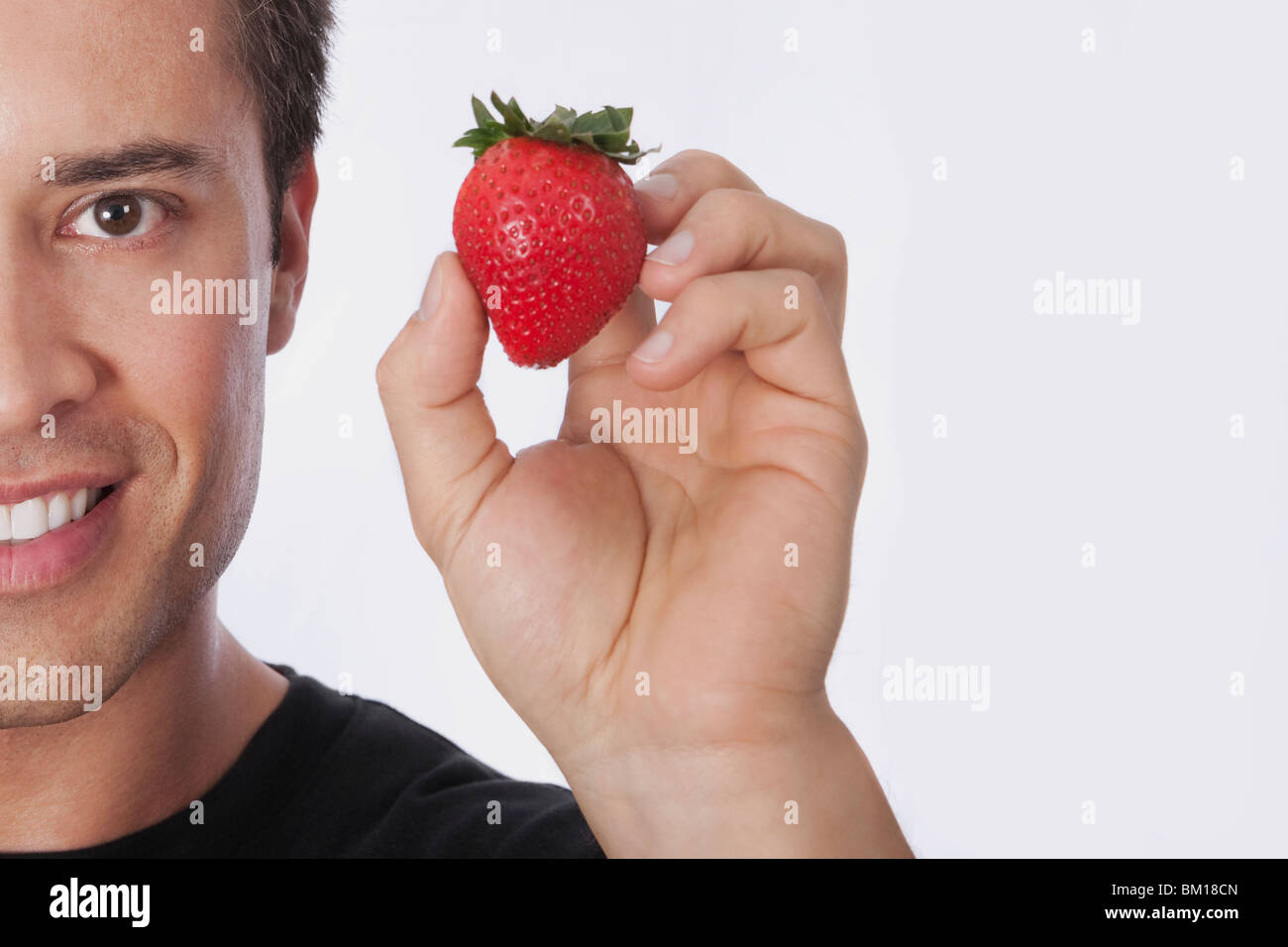 Man holding a strawberry Stock Photo - Alamy
