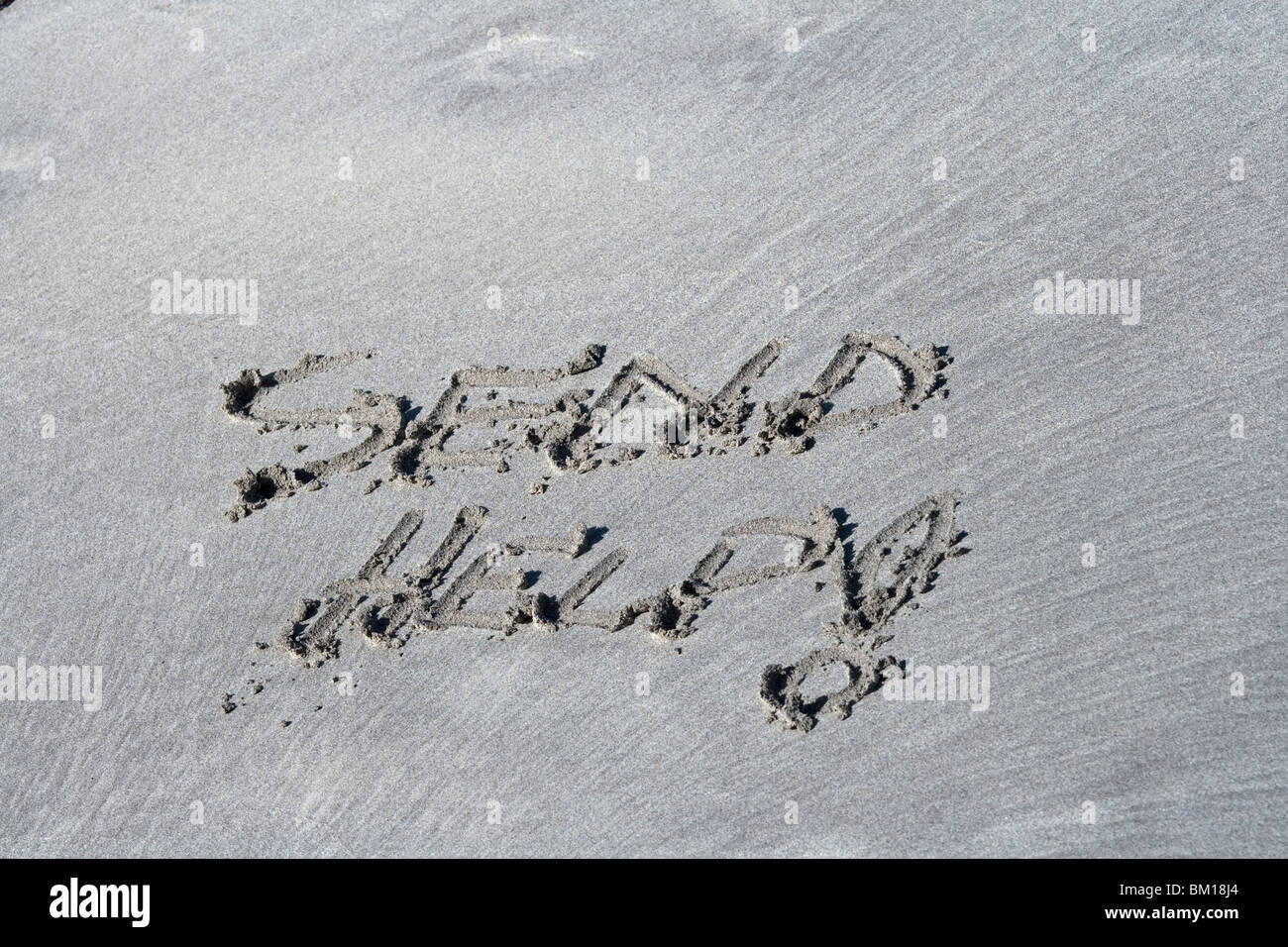 Send help. Rescue message written in the sand Stock Photo - Alamy