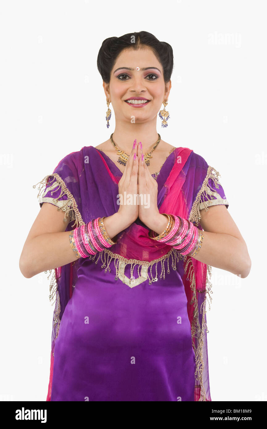 Woman standing in prayer position and smiling Stock Photo - Alamy