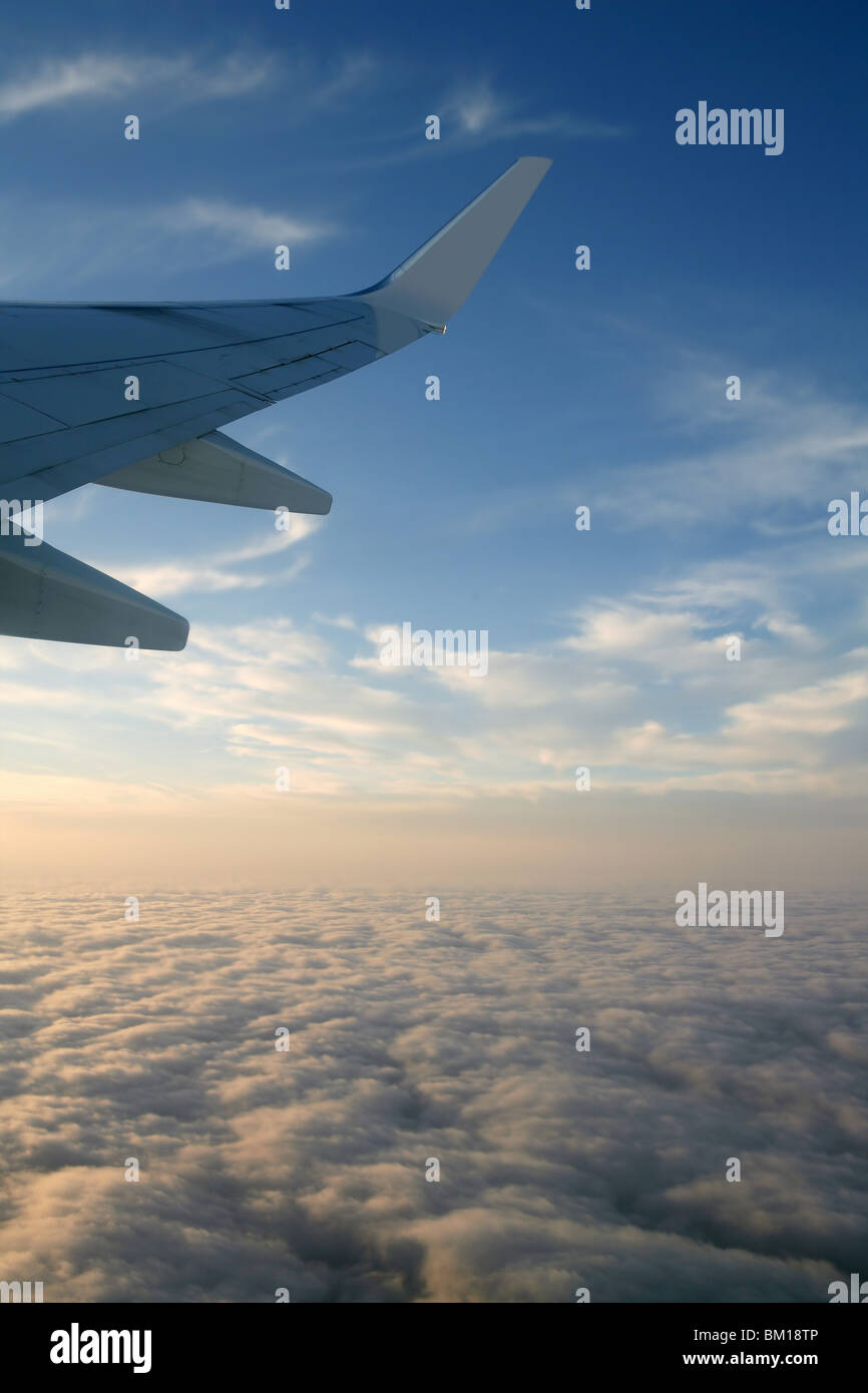 Aircraft right side wing, airplane flying over clouds in a blue sky day ...