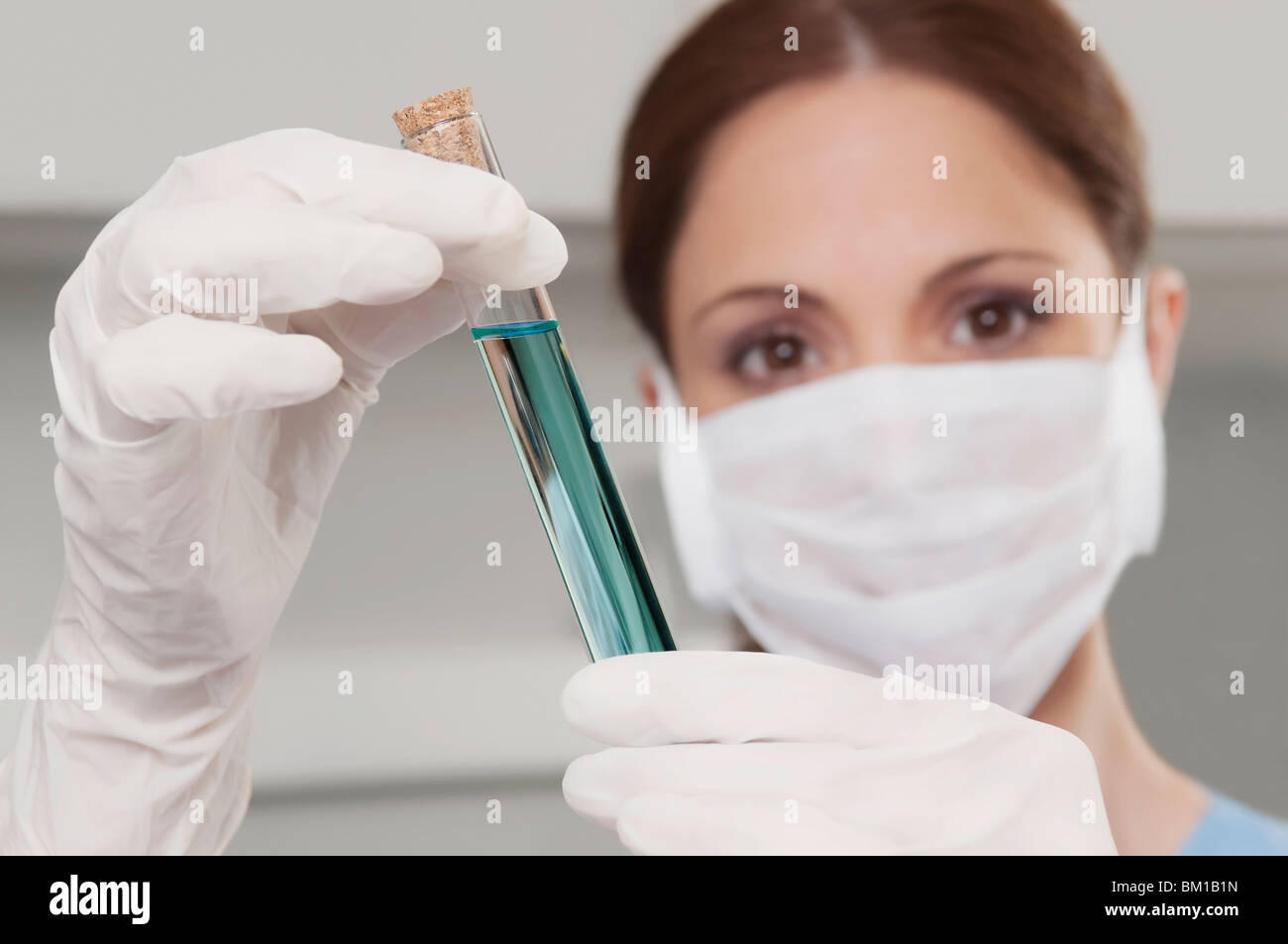 Female lab technician analyzing a sample in a test tube Stock Photo - Alamy