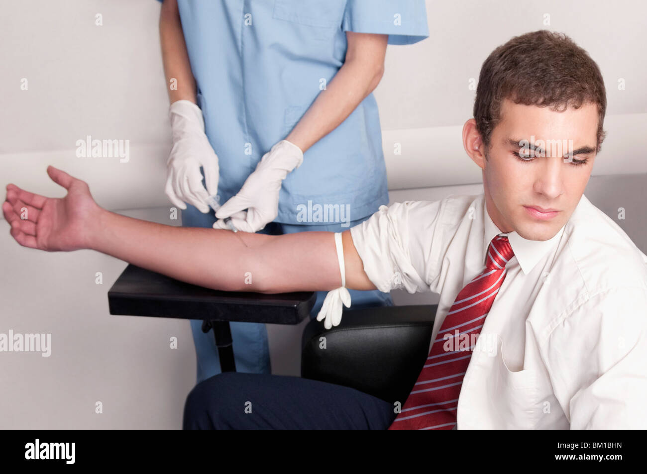 Doctor taking blood sample of a man Stock Photo - Alamy