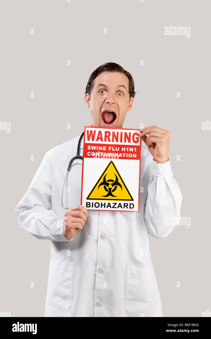 Portrait of a doctor showing a Biohazard warning sign Stock Photo - Alamy