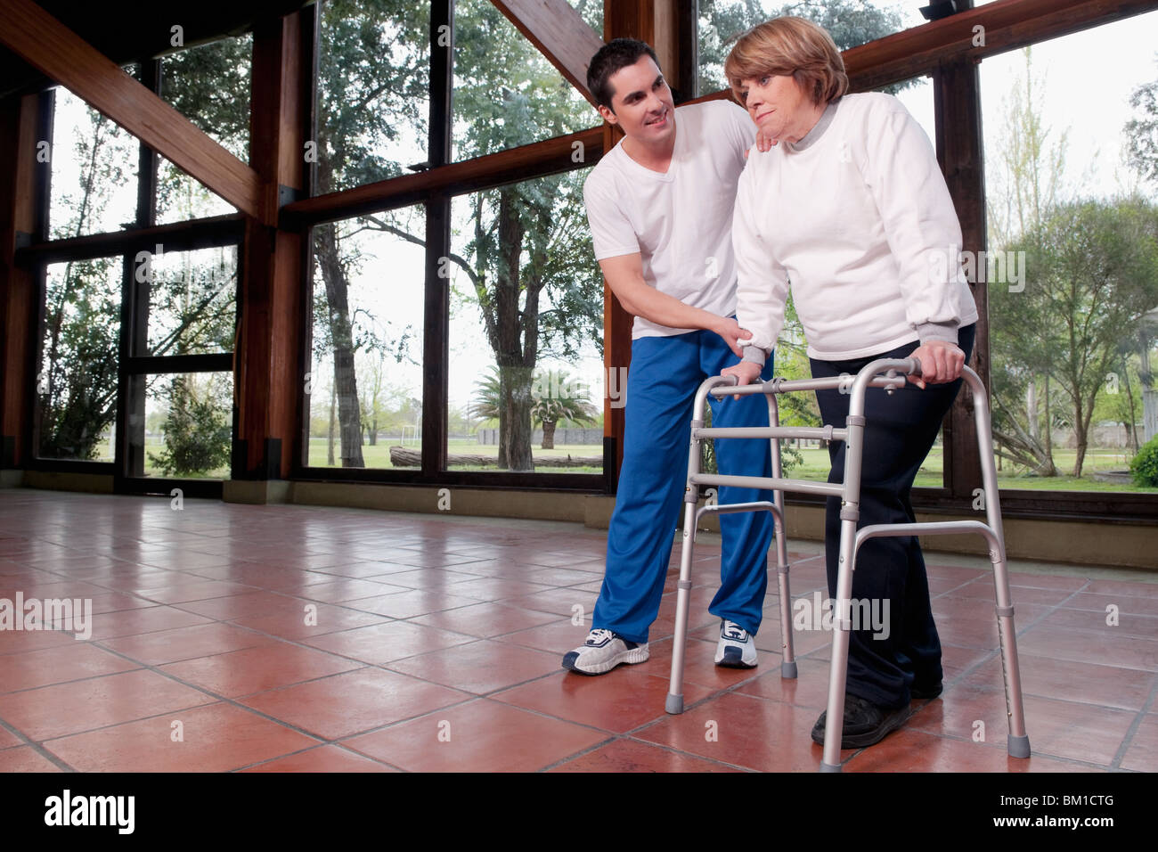 Physiotherapist assisting a woman in walking Stock Photo - Alamy