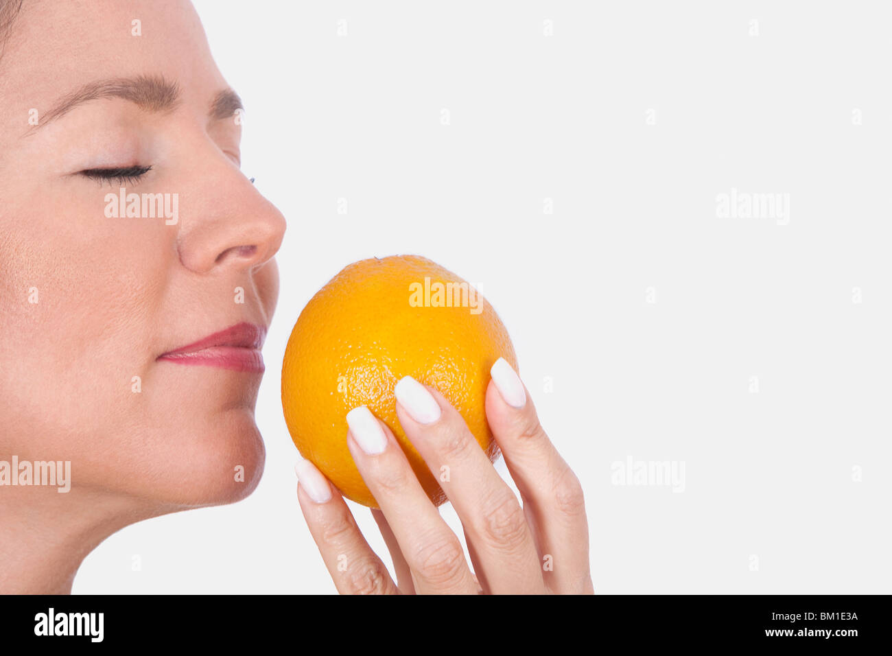 Woman smelling an orange Stock Photo - Alamy
