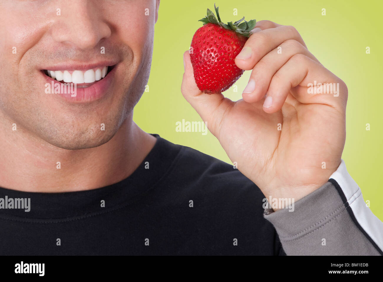 Man holding a strawberry Stock Photo - Alamy