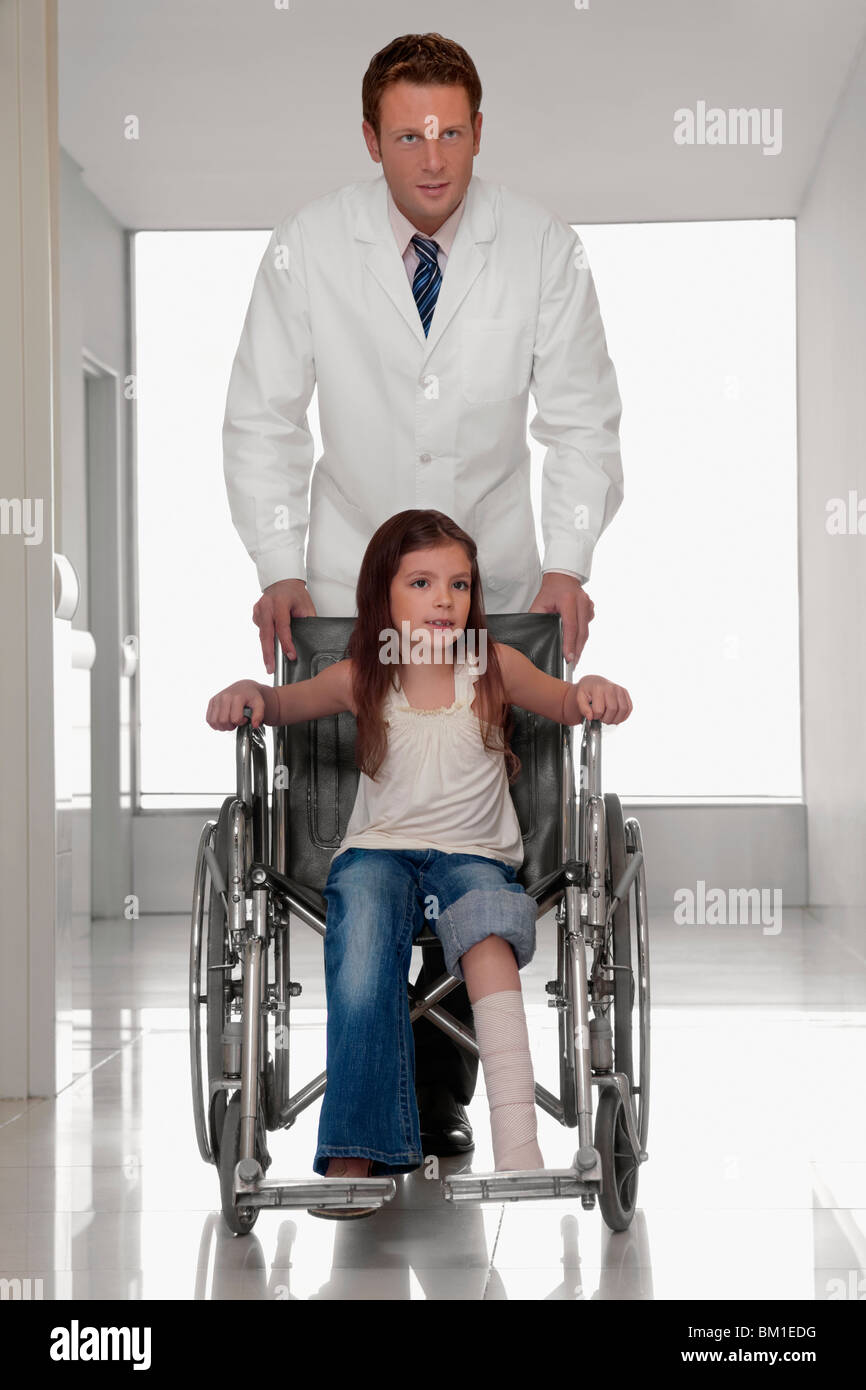 Doctor pushing a patient in a wheelchair Stock Photo - Alamy