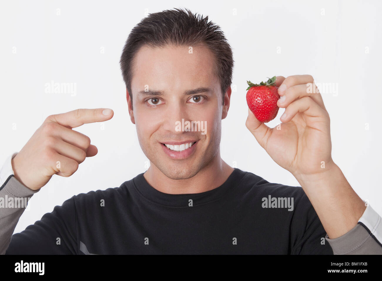 Man eating strawberry looking camera hi-res stock photography and ...