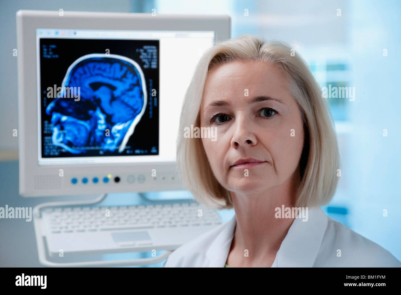 Portrait of a female doctor with an MRI scan of brain on a computer ...