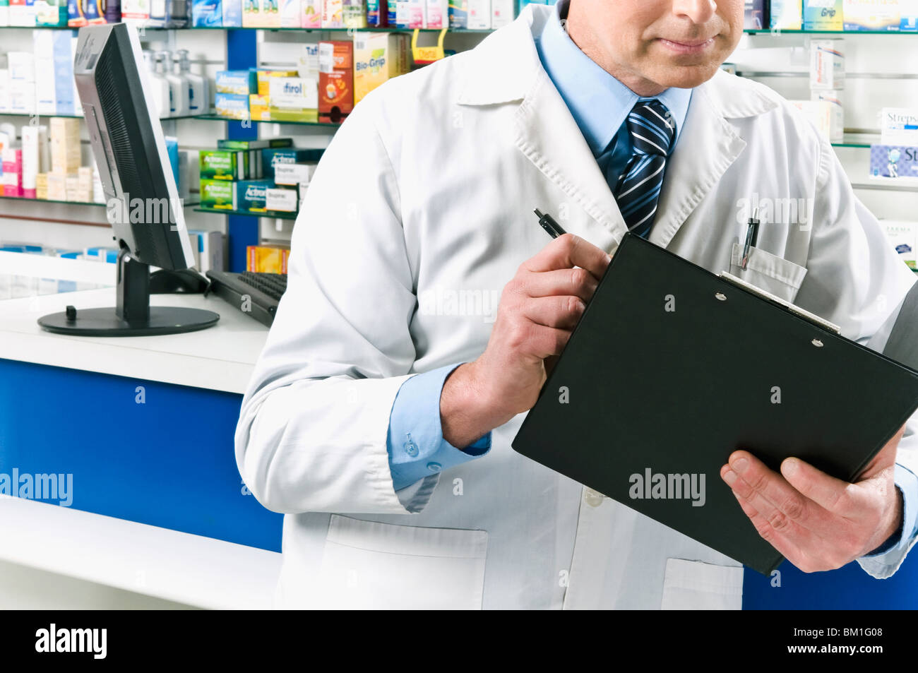 Pharmacist writing in a file Stock Photo - Alamy