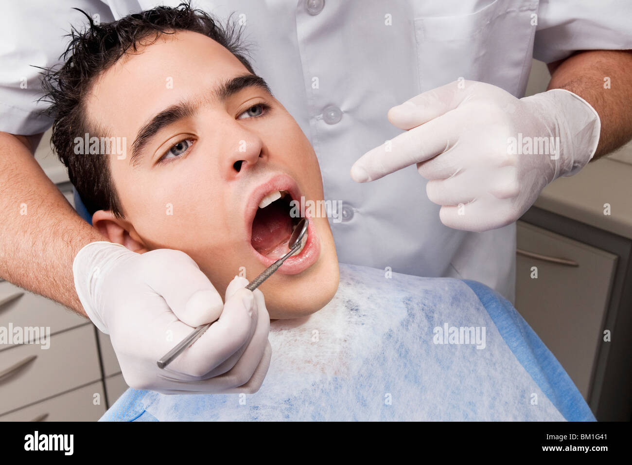 Dentist examining a man's teeth Stock Photo - Alamy