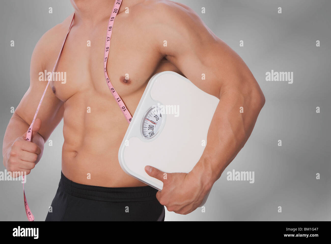 Mid section view of a man holding a bathroom scale Stock Photo - Alamy