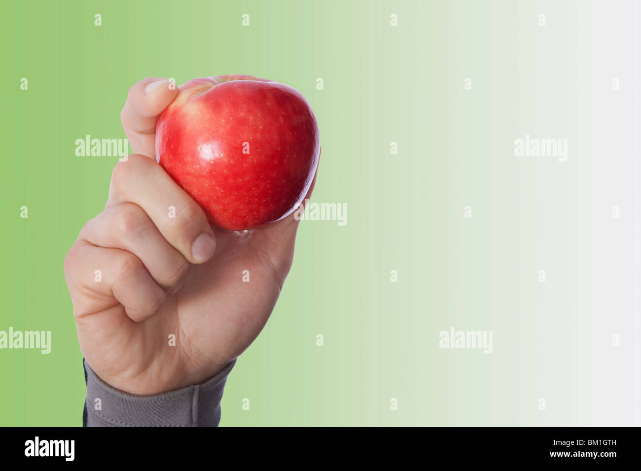 Person's hand holding an apple Stock Photo - Alamy