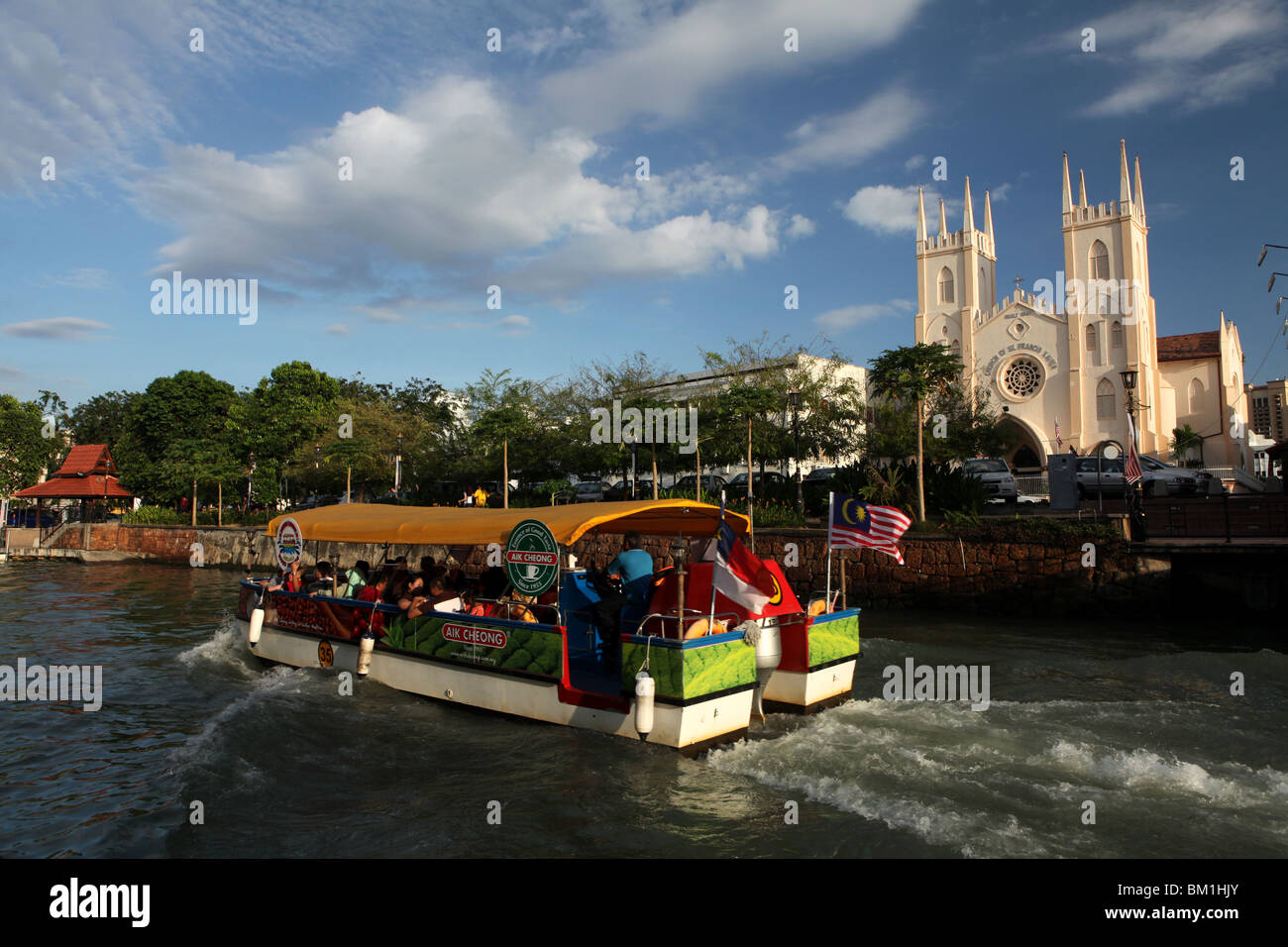 A tourist boat passes St Francis Xavier Church on the Malacca River in ...