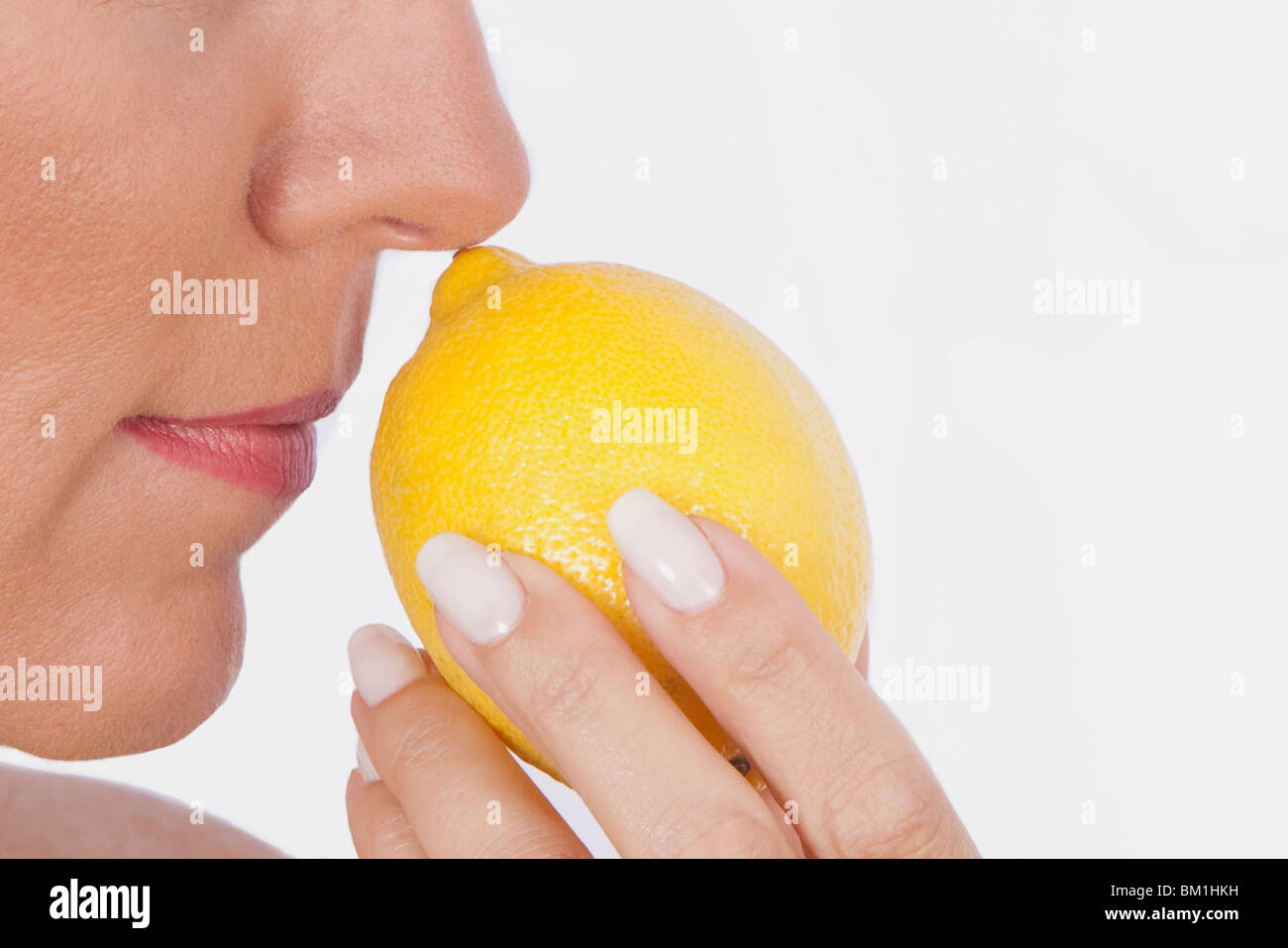 Woman smelling a lemon Stock Photo - Alamy