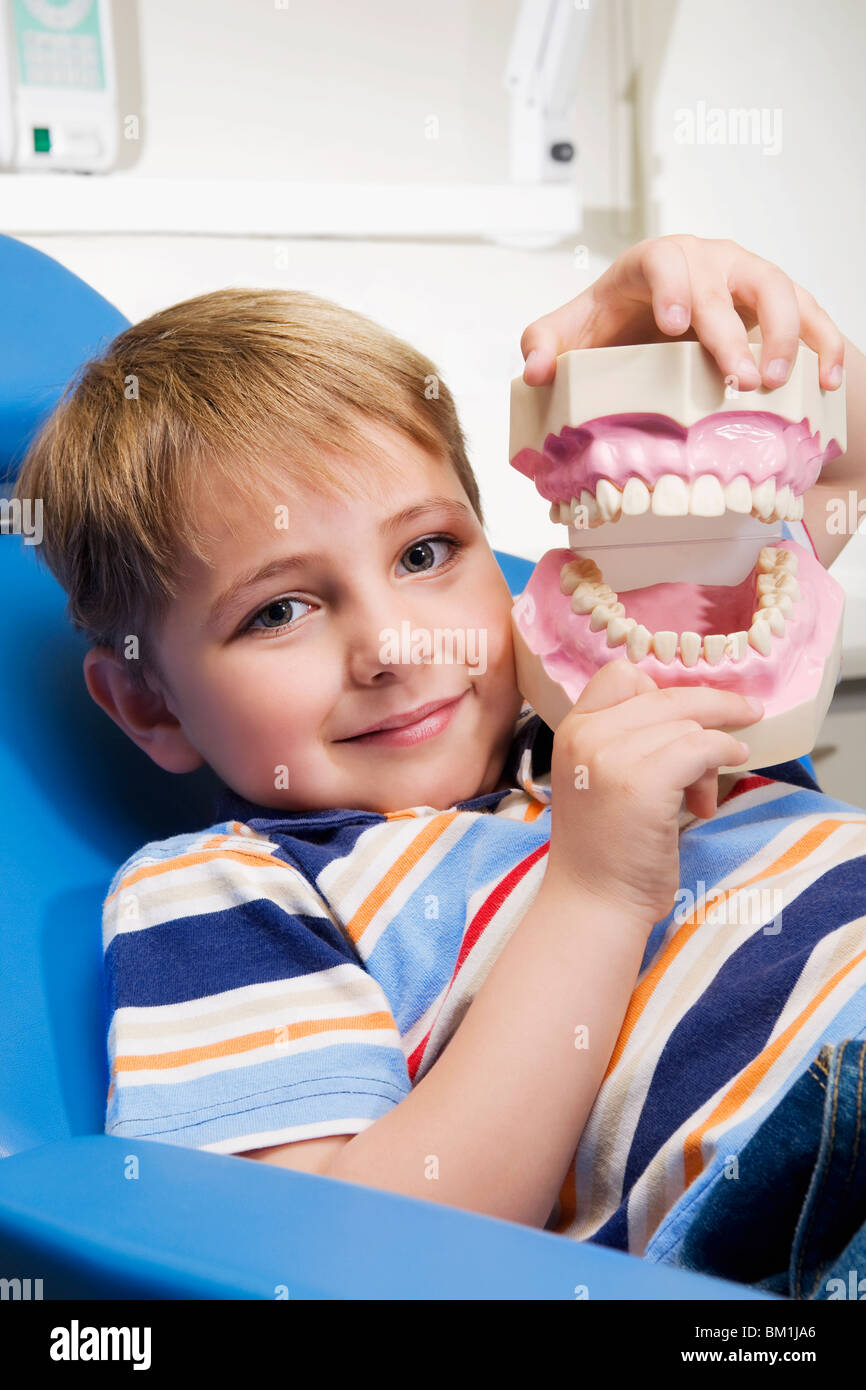 Portrait of a boy holding a set of dentures Stock Photo - Alamy