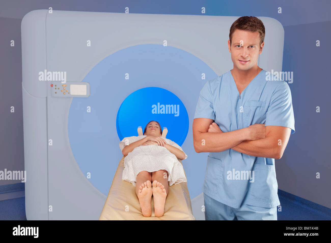 Healthcare worker standing beside a patient undergoing an MRI scan ...