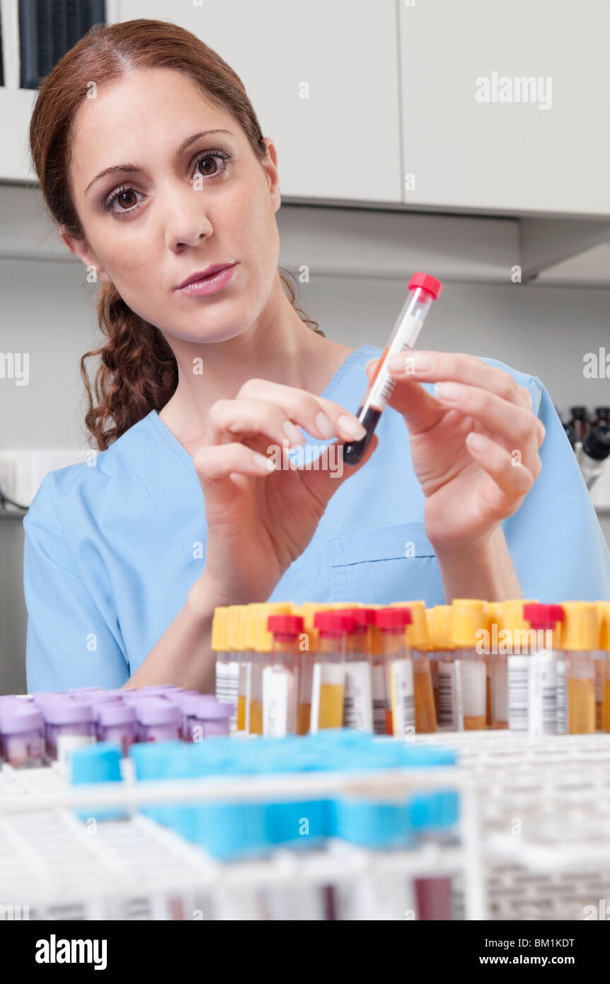 Female lab technician analyzing a blood sample in a test tube Stock ...