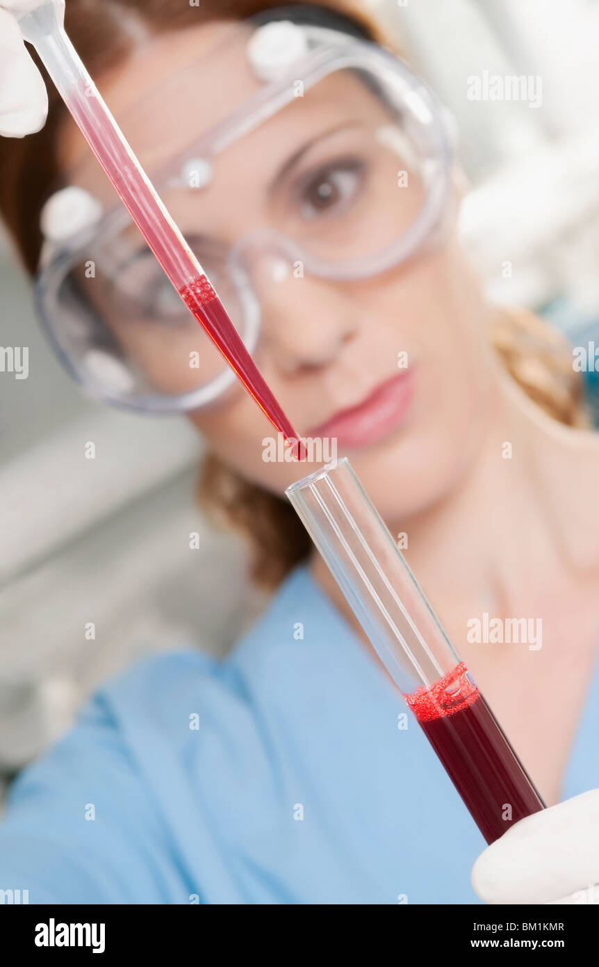 Female lab technician analyzing a blood sample in a test tube Stock ...
