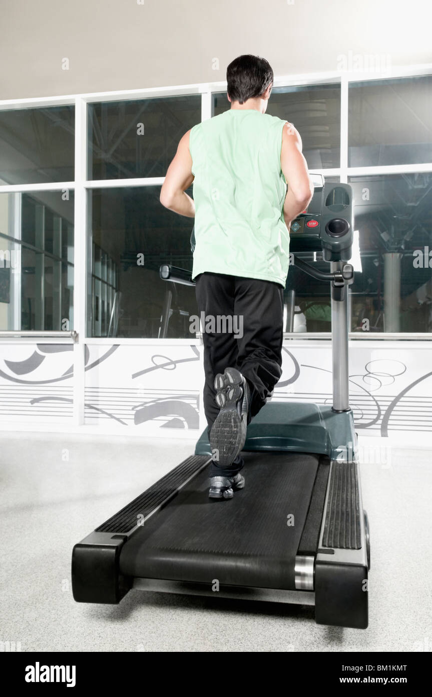 Rear view of a man running on a treadmill Stock Photo - Alamy